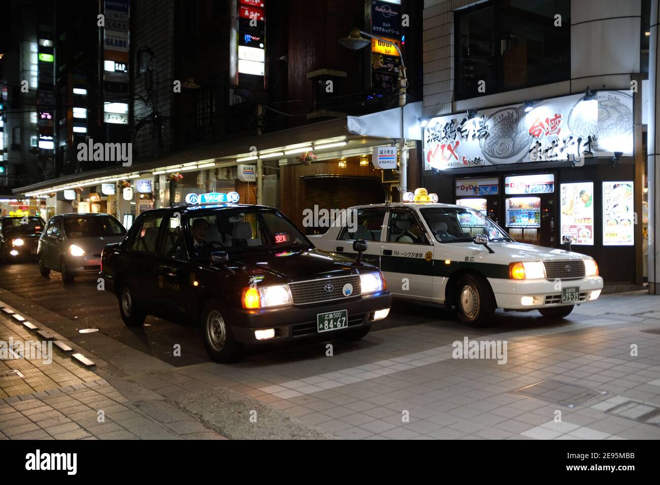 HIROSHIMA, JAPAN - FEBRUARY 2019: Toyota Crown taxis at a traffic light ...
