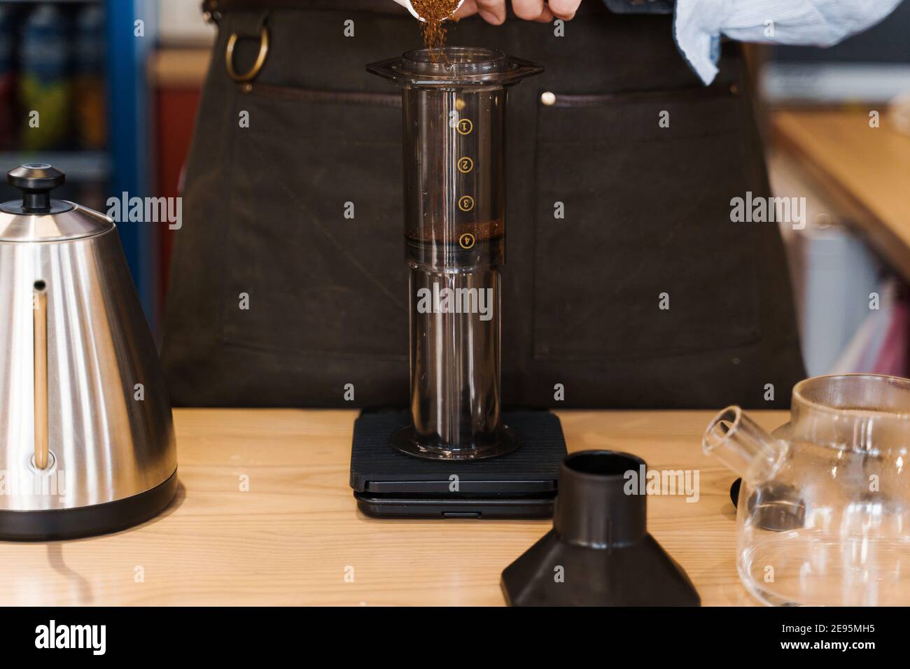 Aeropress coffee: barista spread ground coffee to pot. Alternative coffee brewing method ...