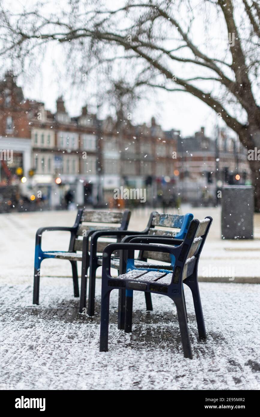 Public seats in Windrush Square during heavy snow, Brixton, London, 24 ...