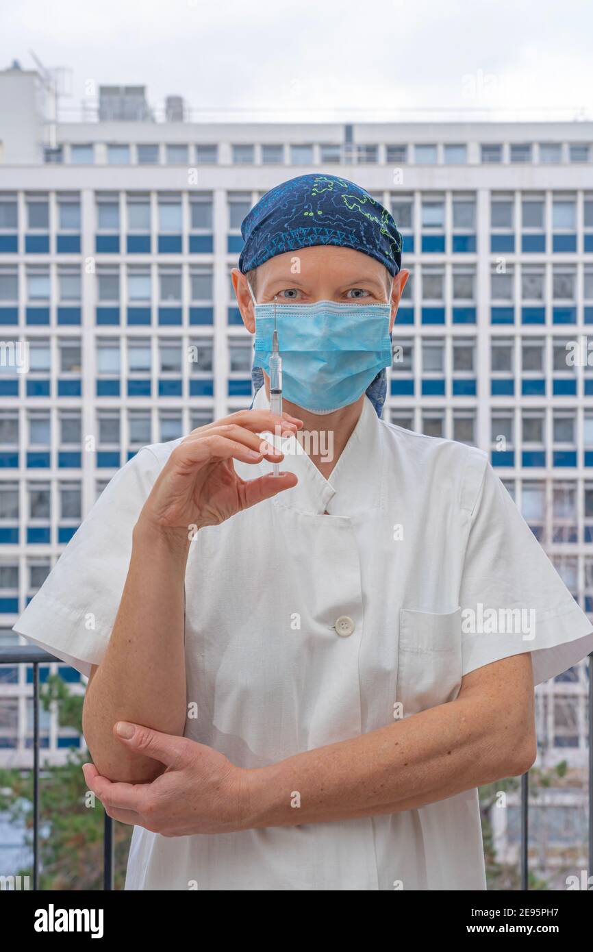 Paris, France - 31 01 2021: Masked nurse dressed in a white lab coat ...