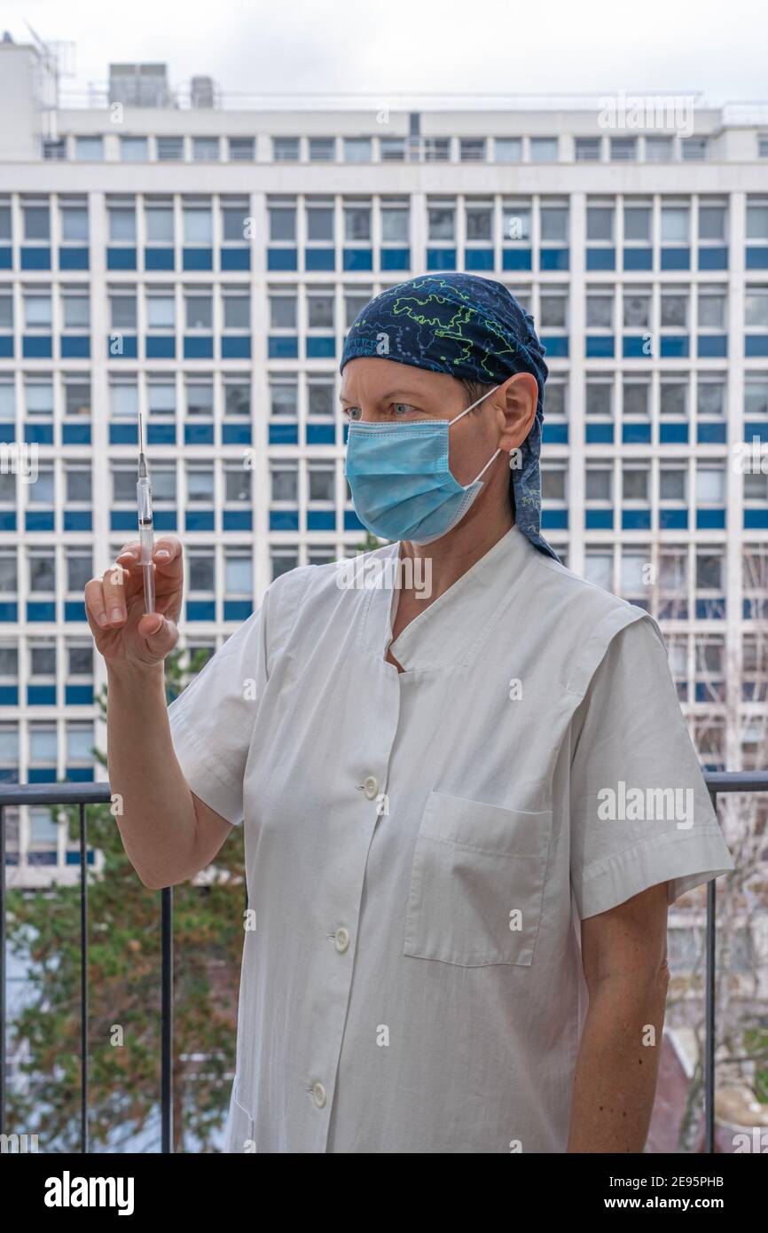 Paris, France - 31 01 2021: Masked nurse dressed in a white lab coat ...