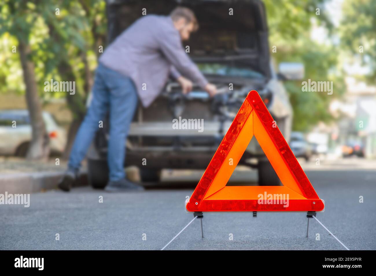 Man fixing car on road. Car Breakdown while driving. Driver looks on ...