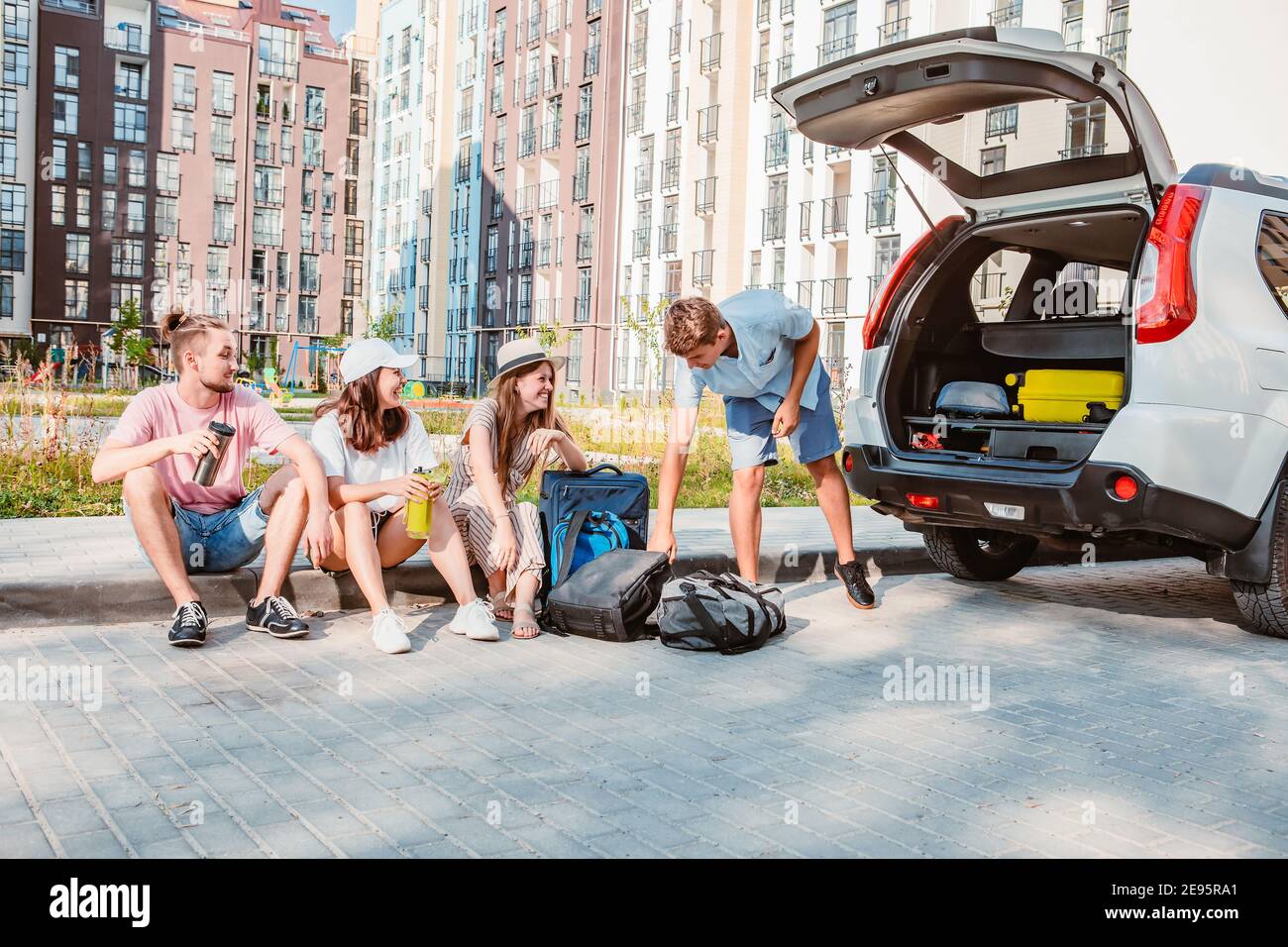 friends load car trunk with baggage. summer road trip vacation Stock ...