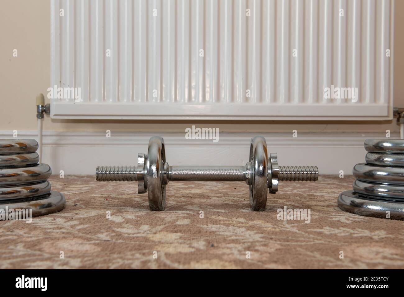 Close up of a small dumbbell on the floor in between a heap of heavier ...