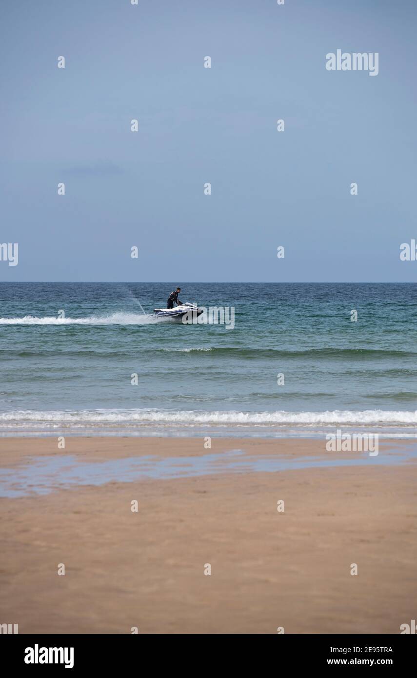 Man riding a jet ski in the sea off the coast of Cornwall, England, UK ...