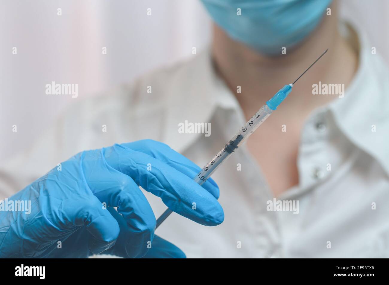 Doctor hands holding the syringe with vaccine. Close-up of a syringe ...