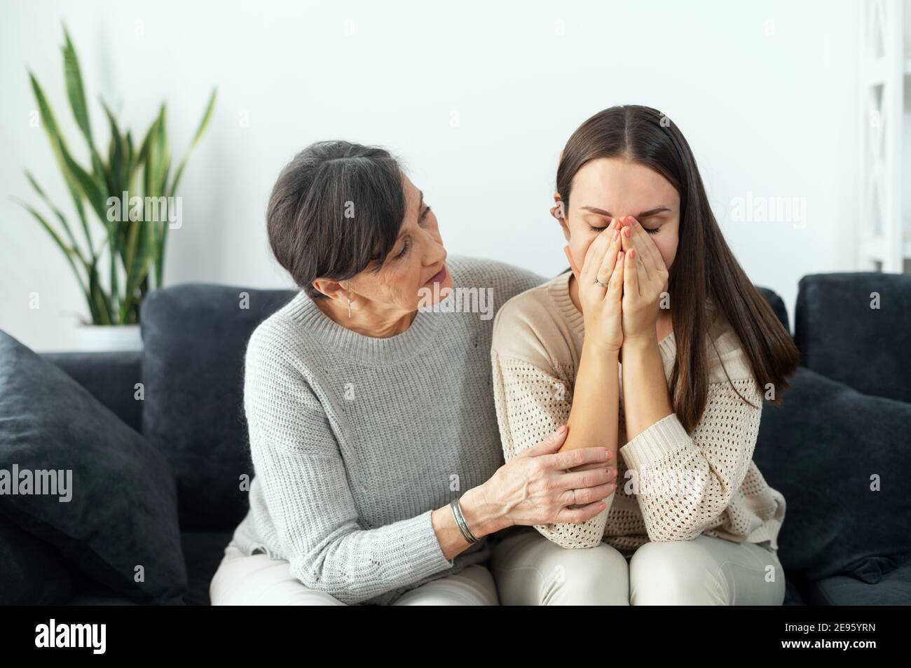 A senior loving mother supports upset depressed adult daughter, caring mature mom embrace sad ...