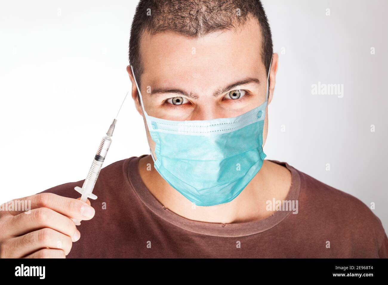 Creepy man wearing a mask and holding vaccine syringe Stock Photo - Alamy