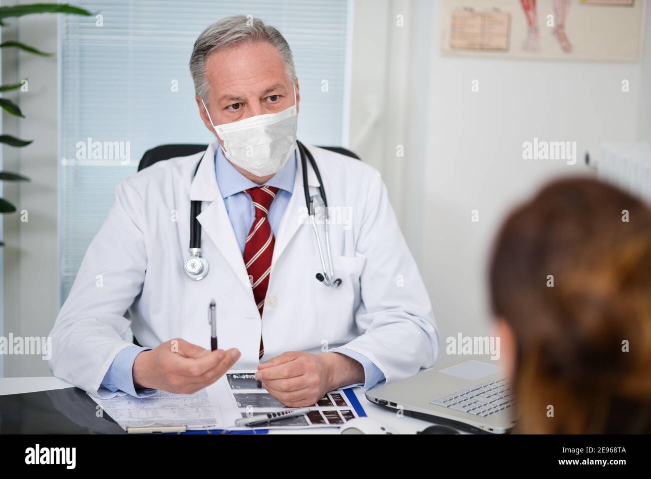 Masked doctor talking to a patient, coronavirus covid concept Stock ...