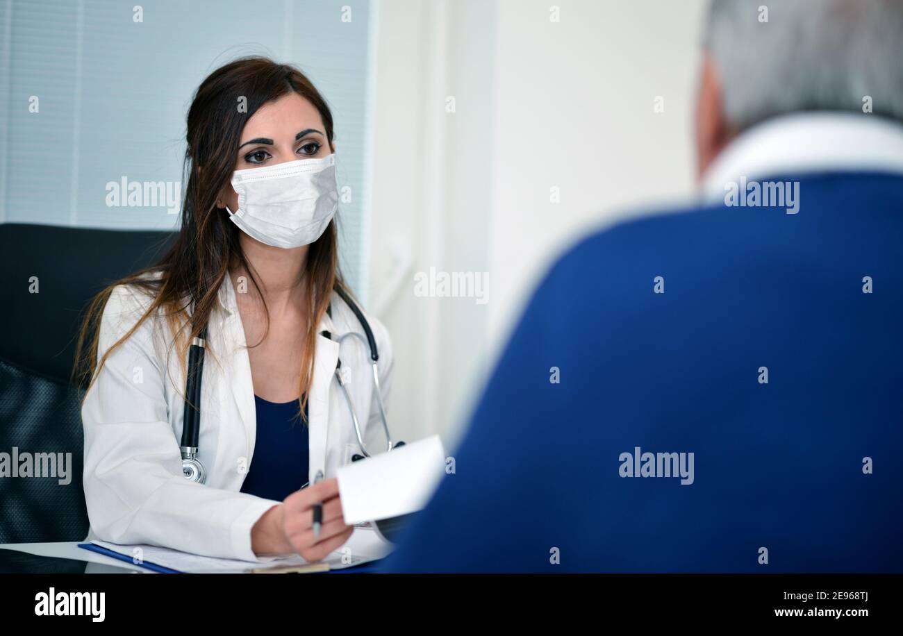 Masked doctor talking to a patient, coronavirus covid concept Stock ...