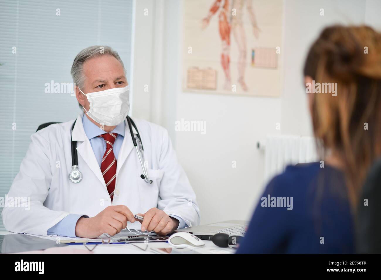 Masked doctor talking to a patient, coronavirus covid concept Stock ...