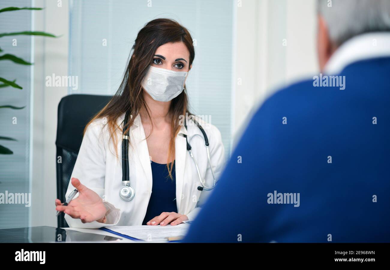 Masked doctor talking to a patient, coronavirus covid concept Stock ...