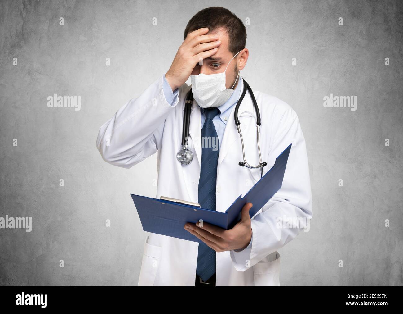 Masked doctor reading a document, covid coronavirus problems concept ...