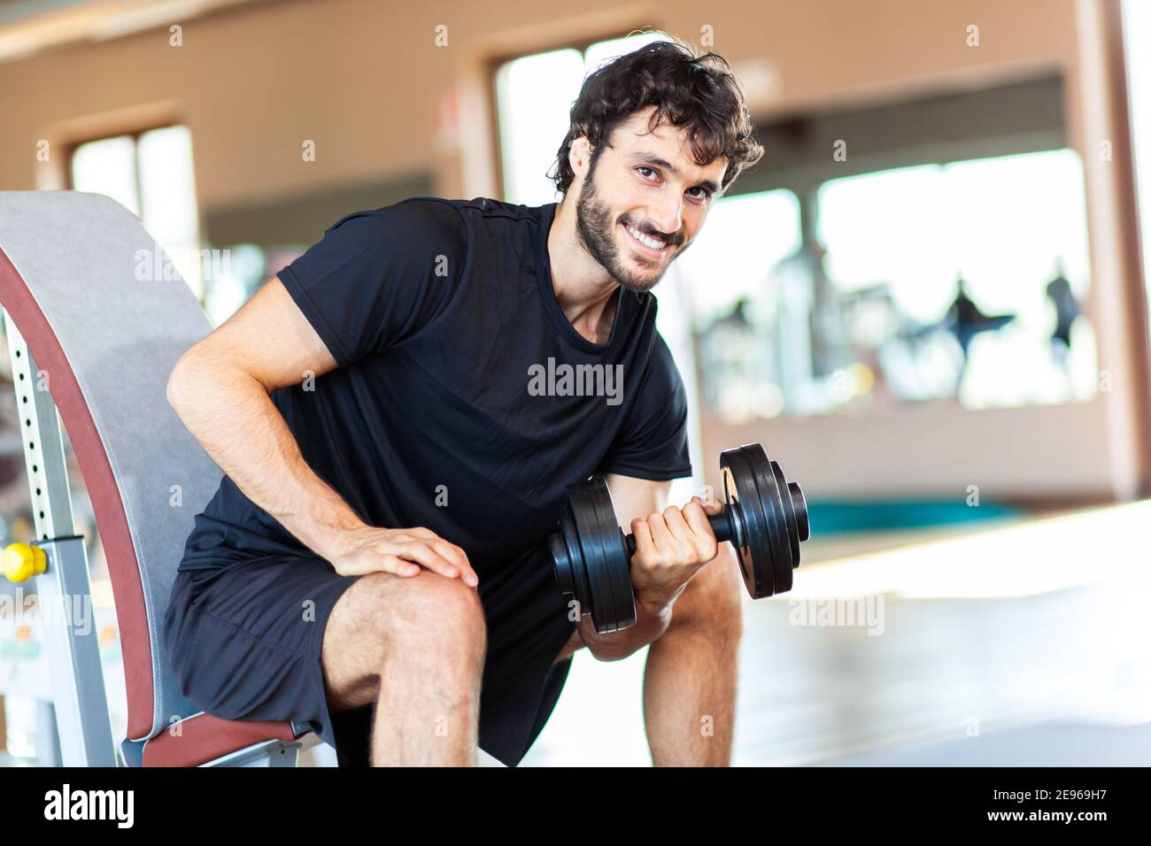 Bodybuilder using a dumbbell to work out his arms in a gym Stock Photo ...