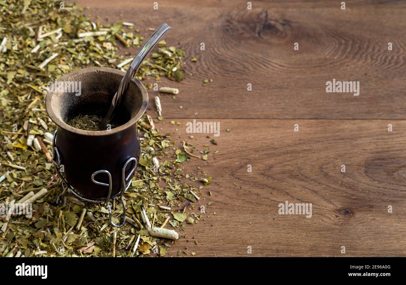 Traditional mate made of calabash over a wooden table with yerba mate ...