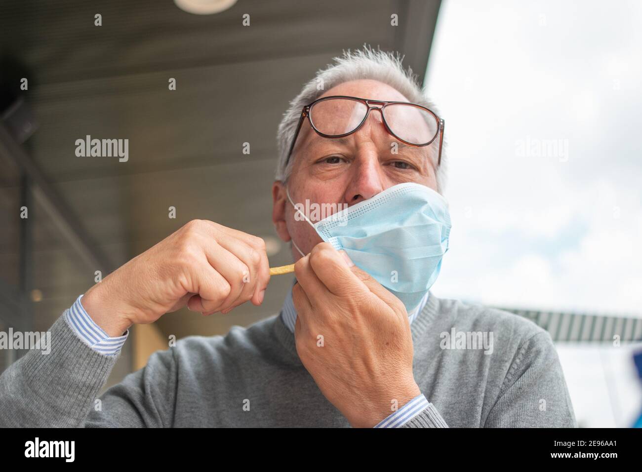 Mature man trying to eat a french fry wearing a mask, funny coronavirus ...