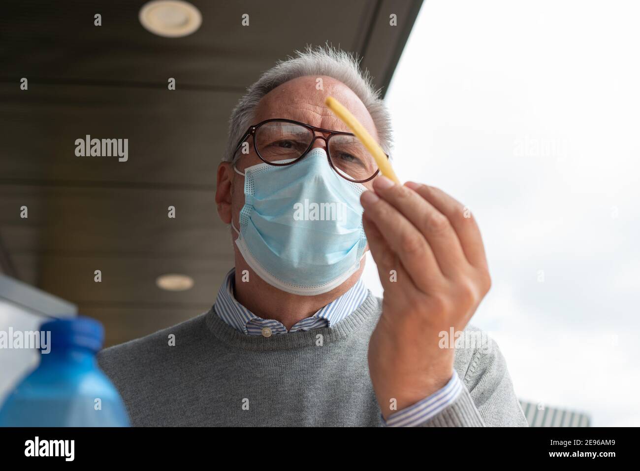 Mature man trying to eat a french fry wearing a mask, funny coronavirus ...