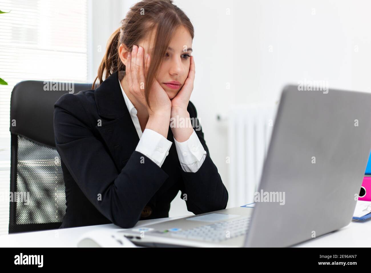 Bored secretary at her desk Stock Photo - Alamy