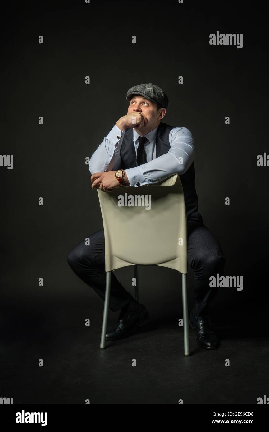 in a cap on a chair Young male three piece suit business man ...