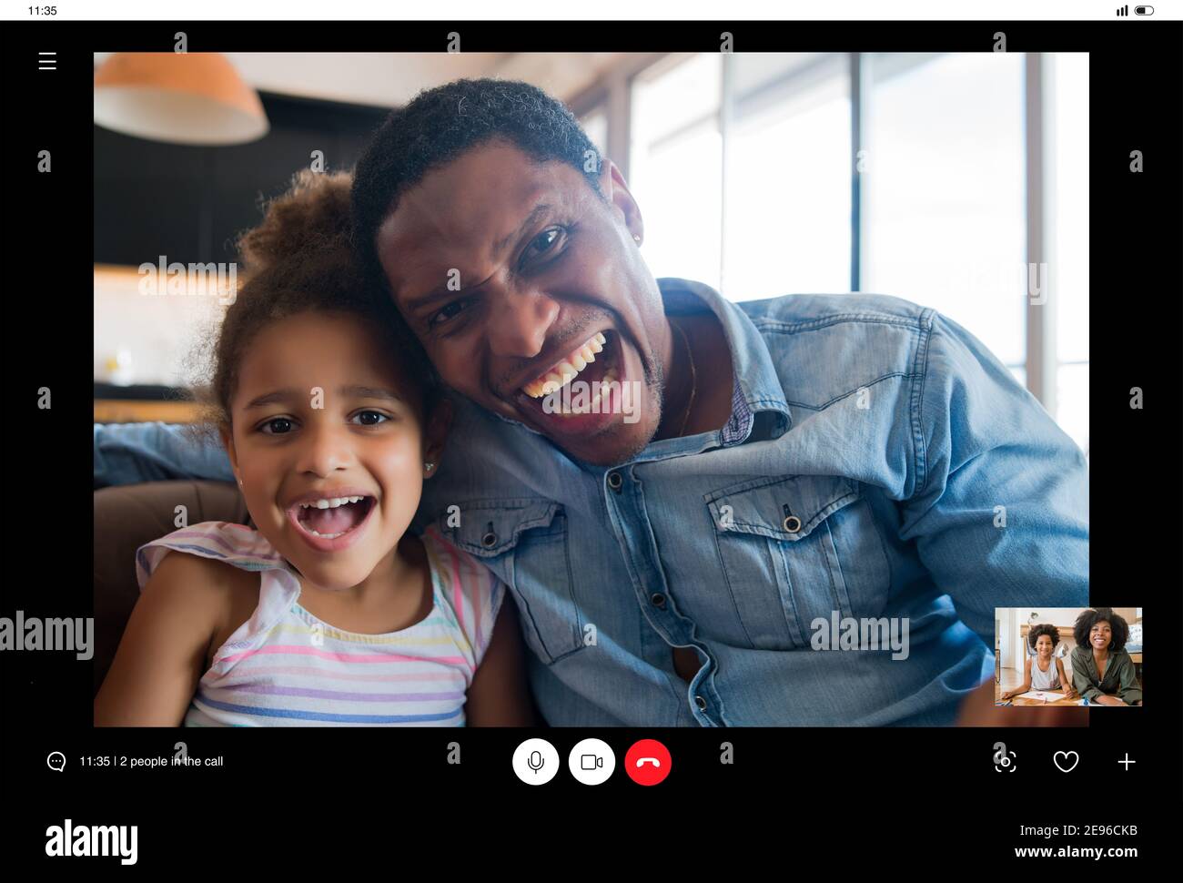 Family smiling and having good time together on a video call while ...