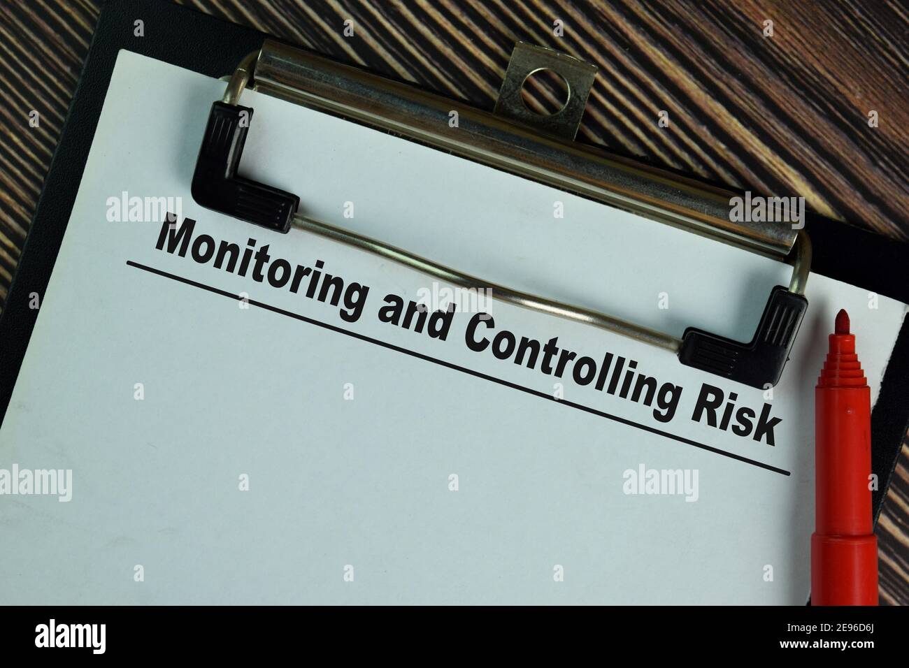 Monitoring and Controlling Risk write on a paperwork isolated on Wooden ...