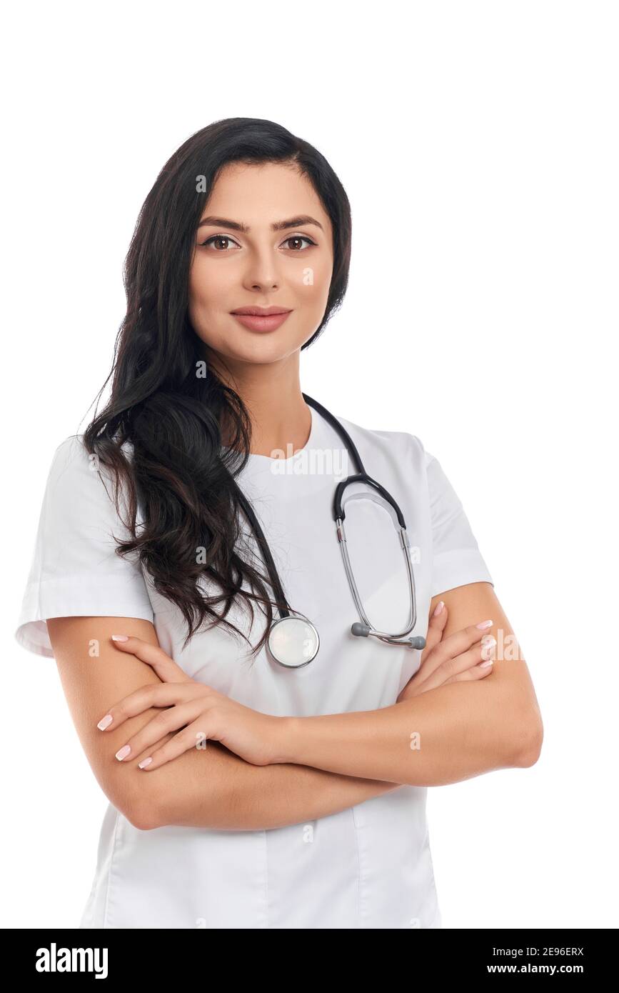 Positive young doctor dressed in white medical uniform standing in ...
