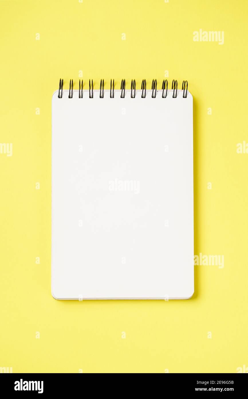 School notebook on a paper yellow background, spiral notepad and craft ...