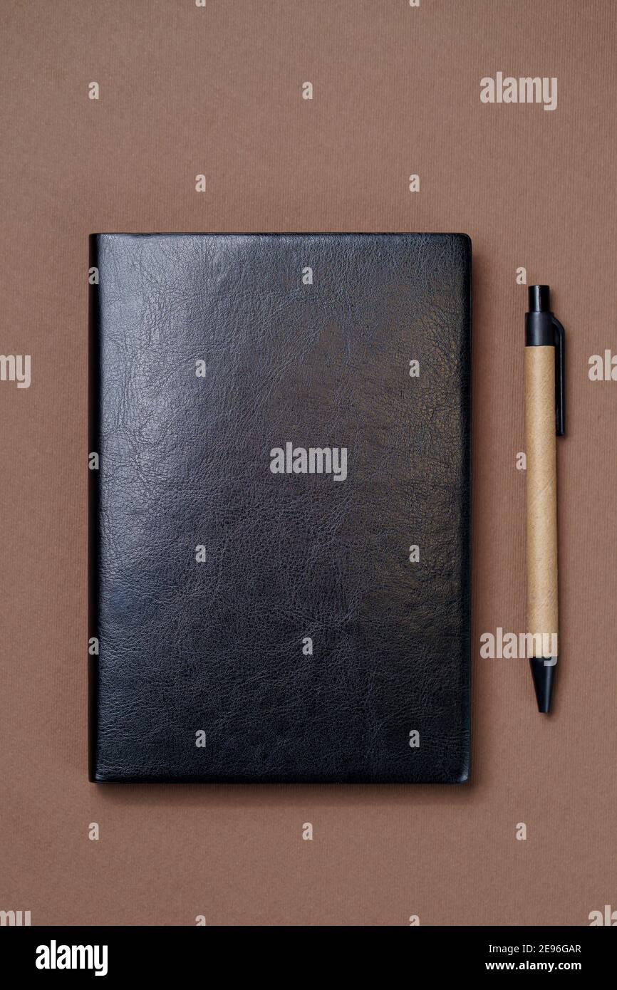 Black leather notebook on a paper brown background, notepad mock up ...