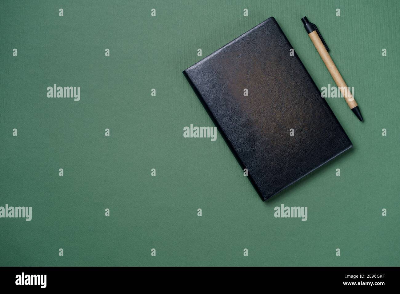 Black leather notebook on a paper green background, notepad mock up ...