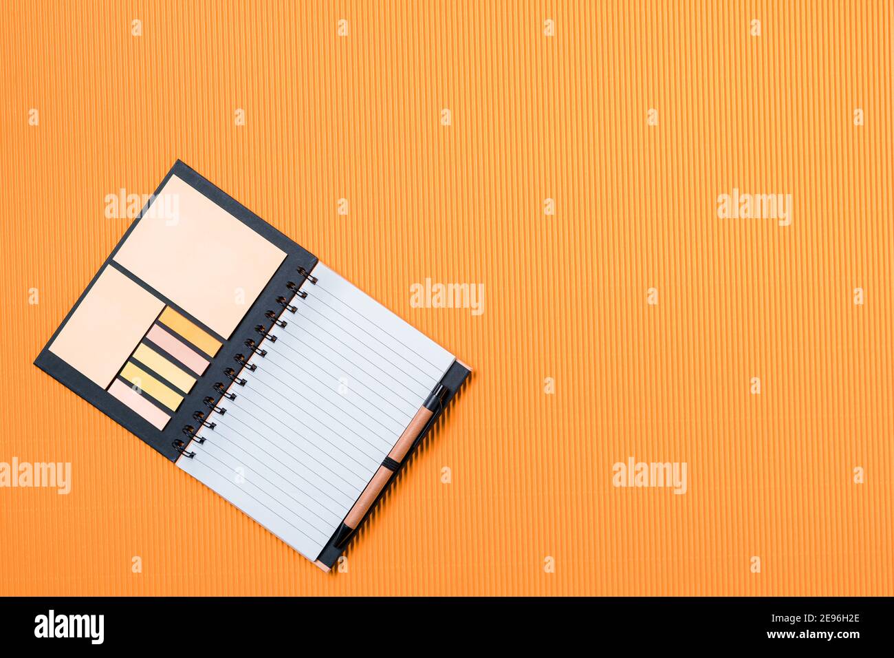 School notebook on a paper orange background, spiral notepad and craft ...