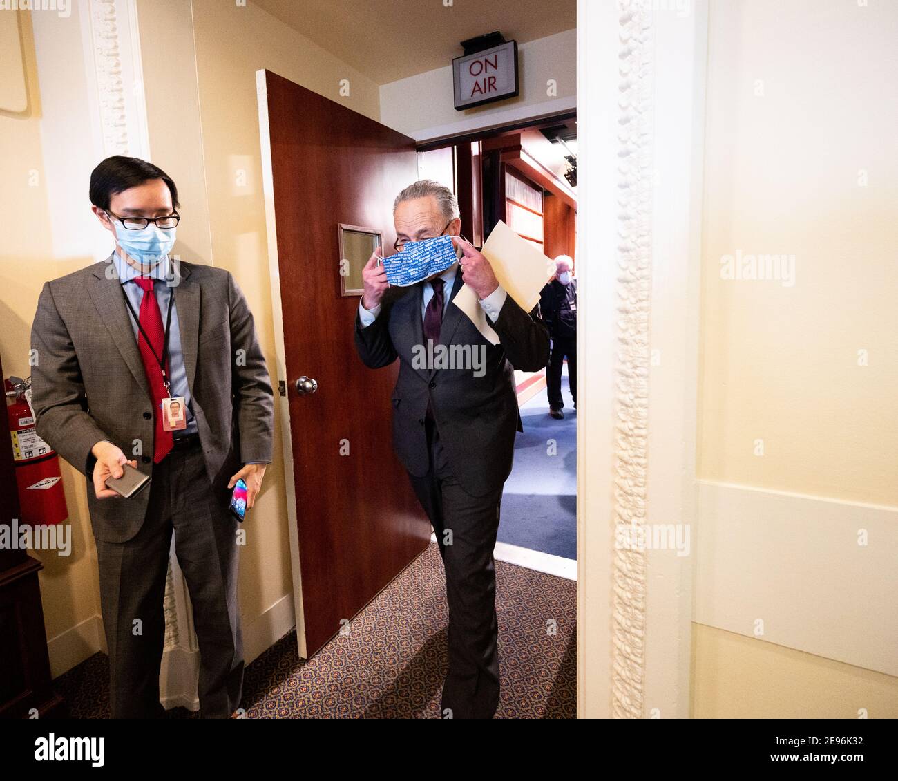 Senate Majority Leader Chuck Schumer (D-NY) puts on a face mask as he ...