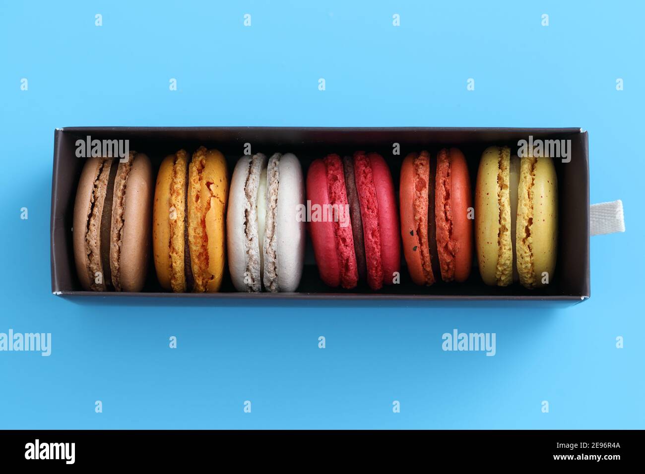 Colorful macarons isolated in blue background Stock Photo - Alamy