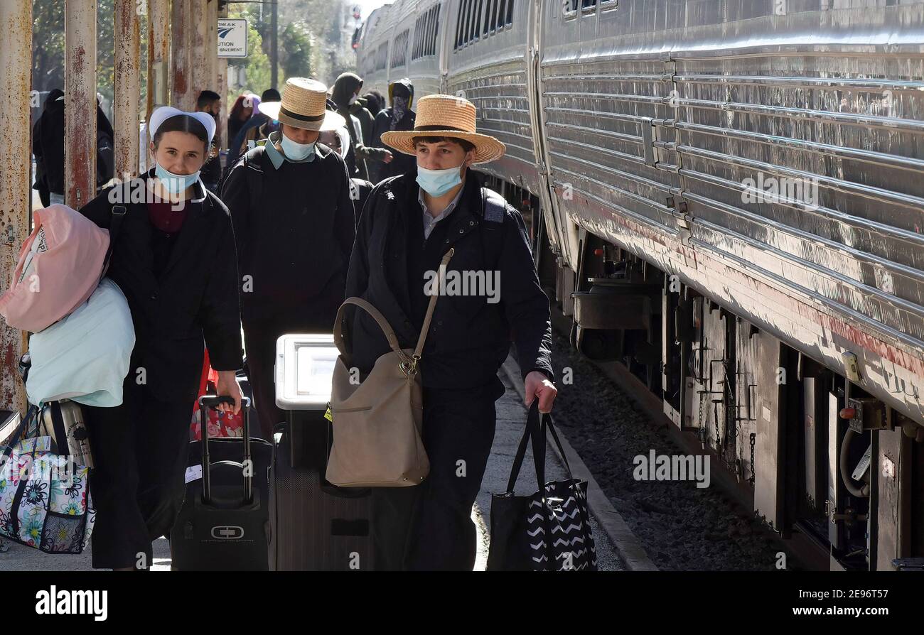 Rail passengers wearing face masks walk on the platform after exiting a ...