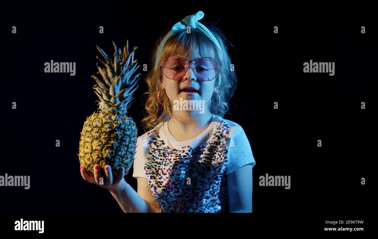 Cute child kid in neon lighting posing at disco party cyberpunk studio ...