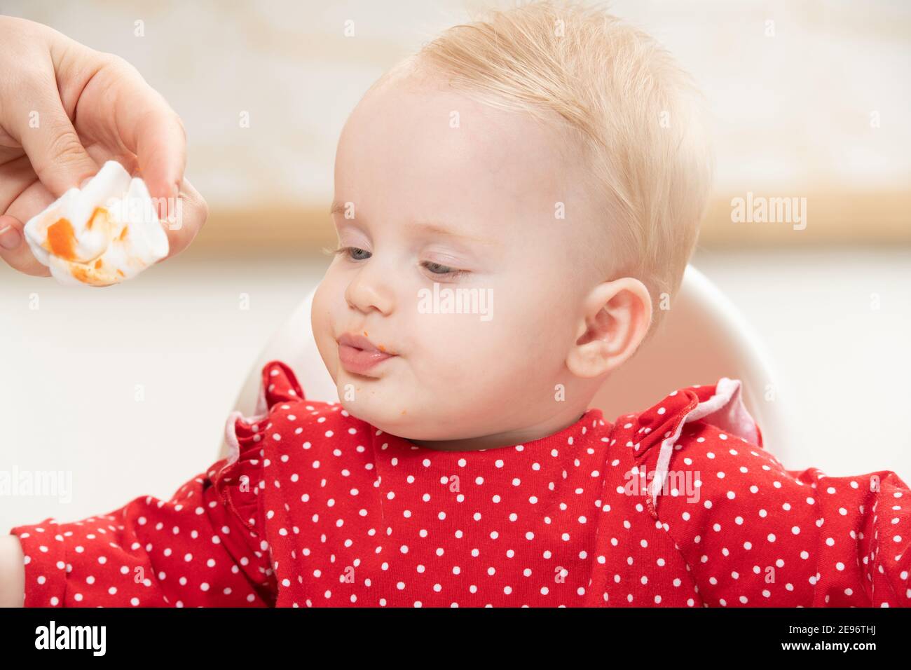 Mother Wipes Baby's Mouth With Napkin After Feeding Her Baby Daughter ...