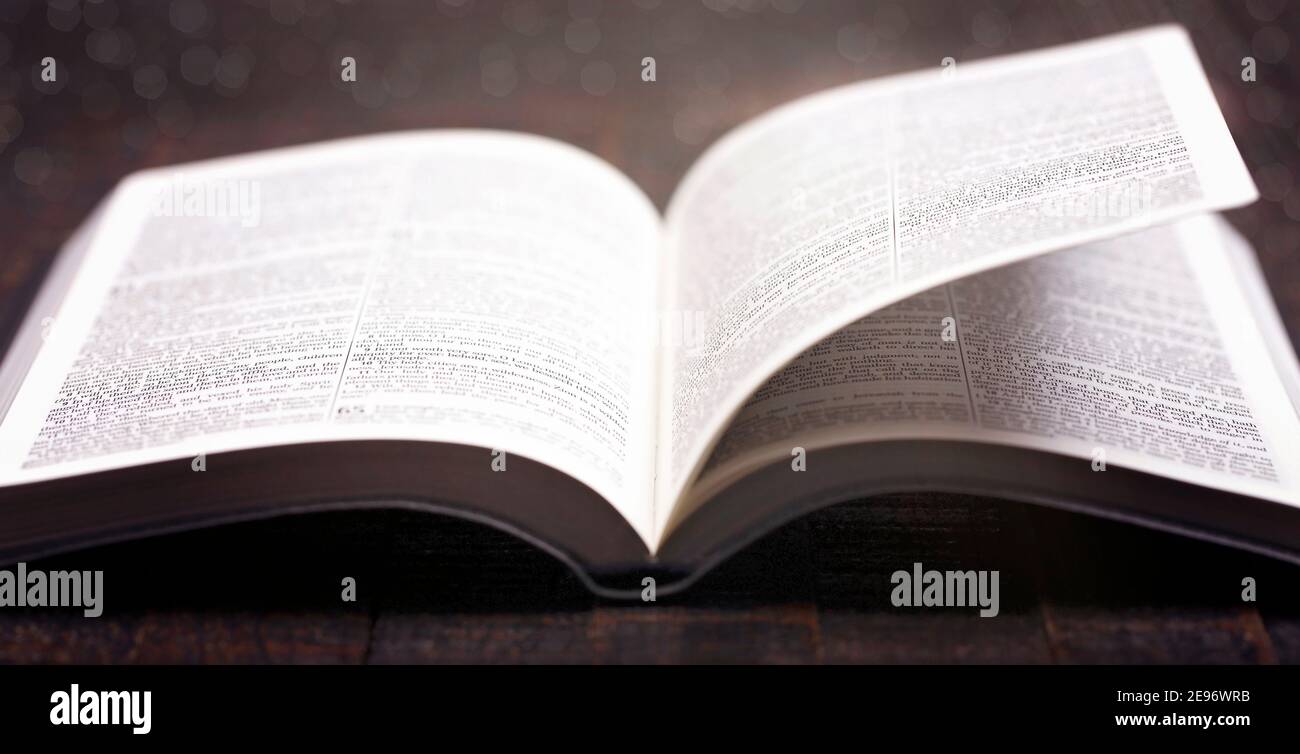 Bible Open on a Rustic Wooden Table with Pages Blowing Open Stock Photo ...
