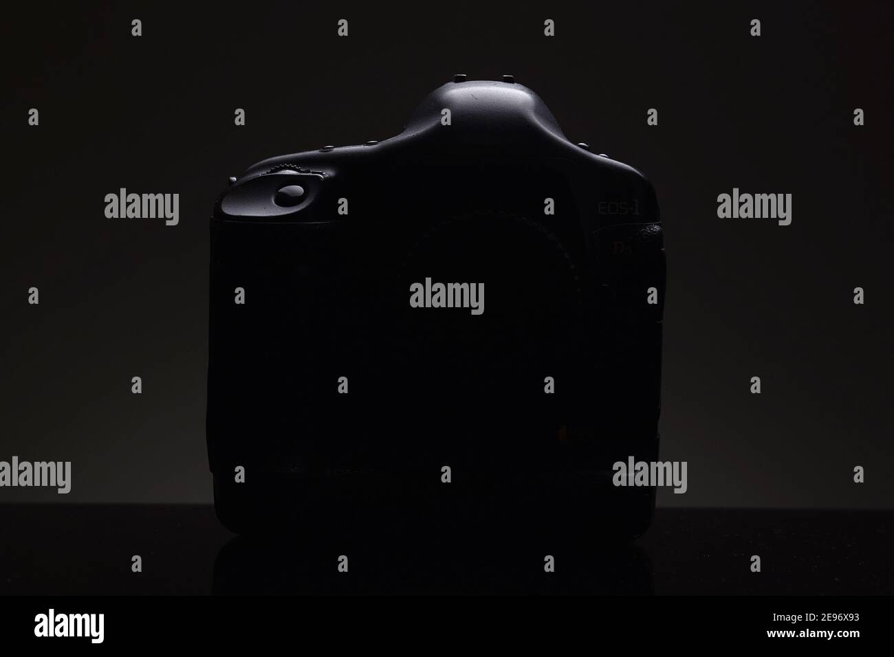 The silhouette of a professional SLR camera on a black background ...