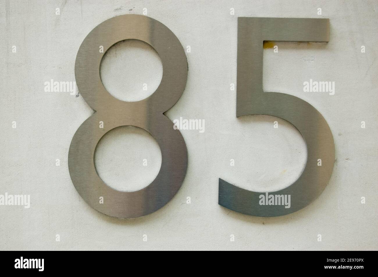 Polished metal number eighty five on public display outside an office ...