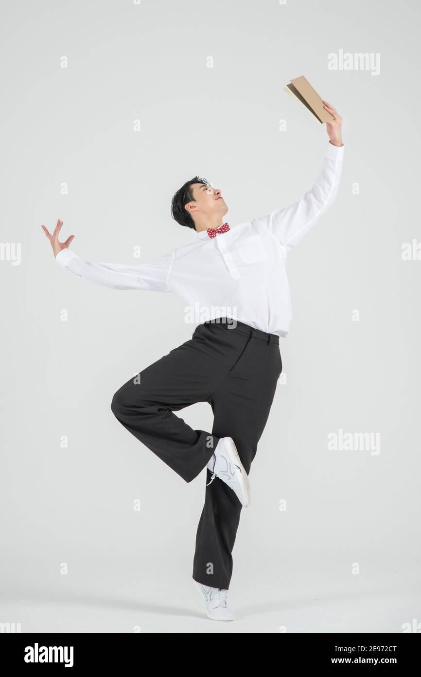 Asian male contemporary dancer holding book Stock Photo - Alamy