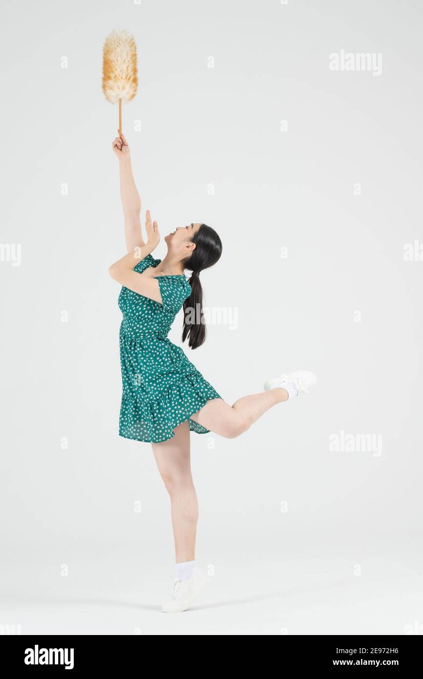 Asian female contemporary dancer holding cleaning tool Stock Photo - Alamy