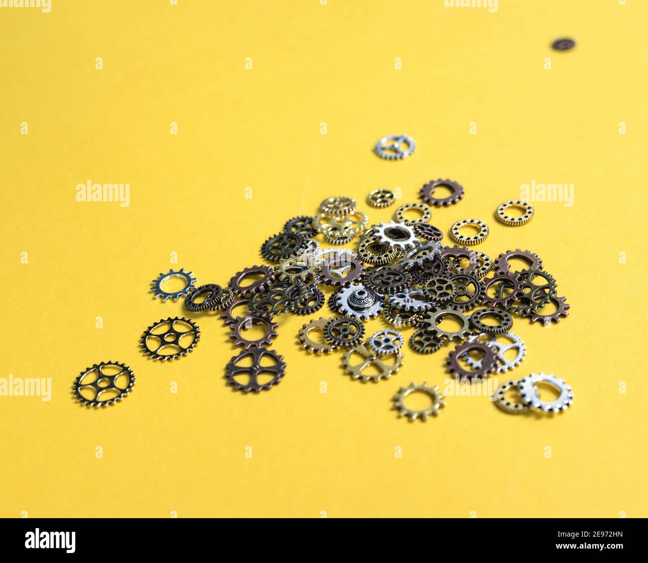 Brass cog wheels of different sizes lying on yellow background Stock ...