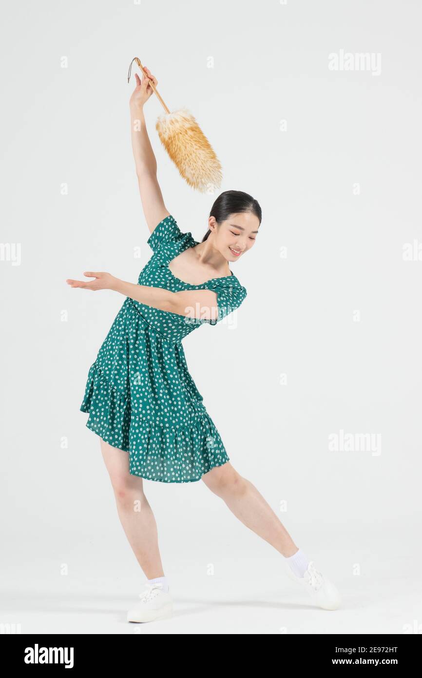 Asian female contemporary dancer holding cleaning tool Stock Photo - Alamy