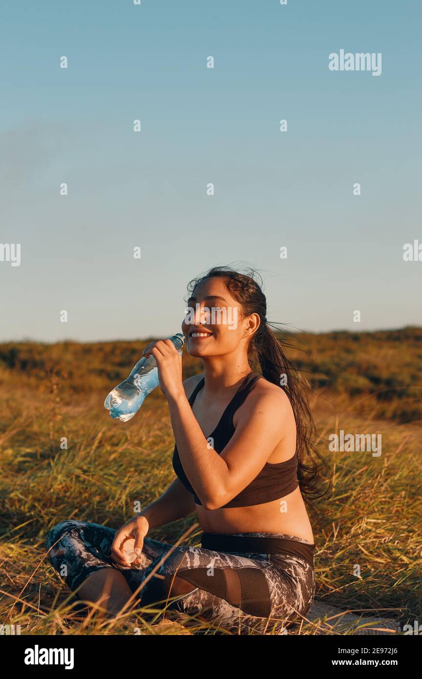 A woman smiling before drinking water after sport activities Stock ...