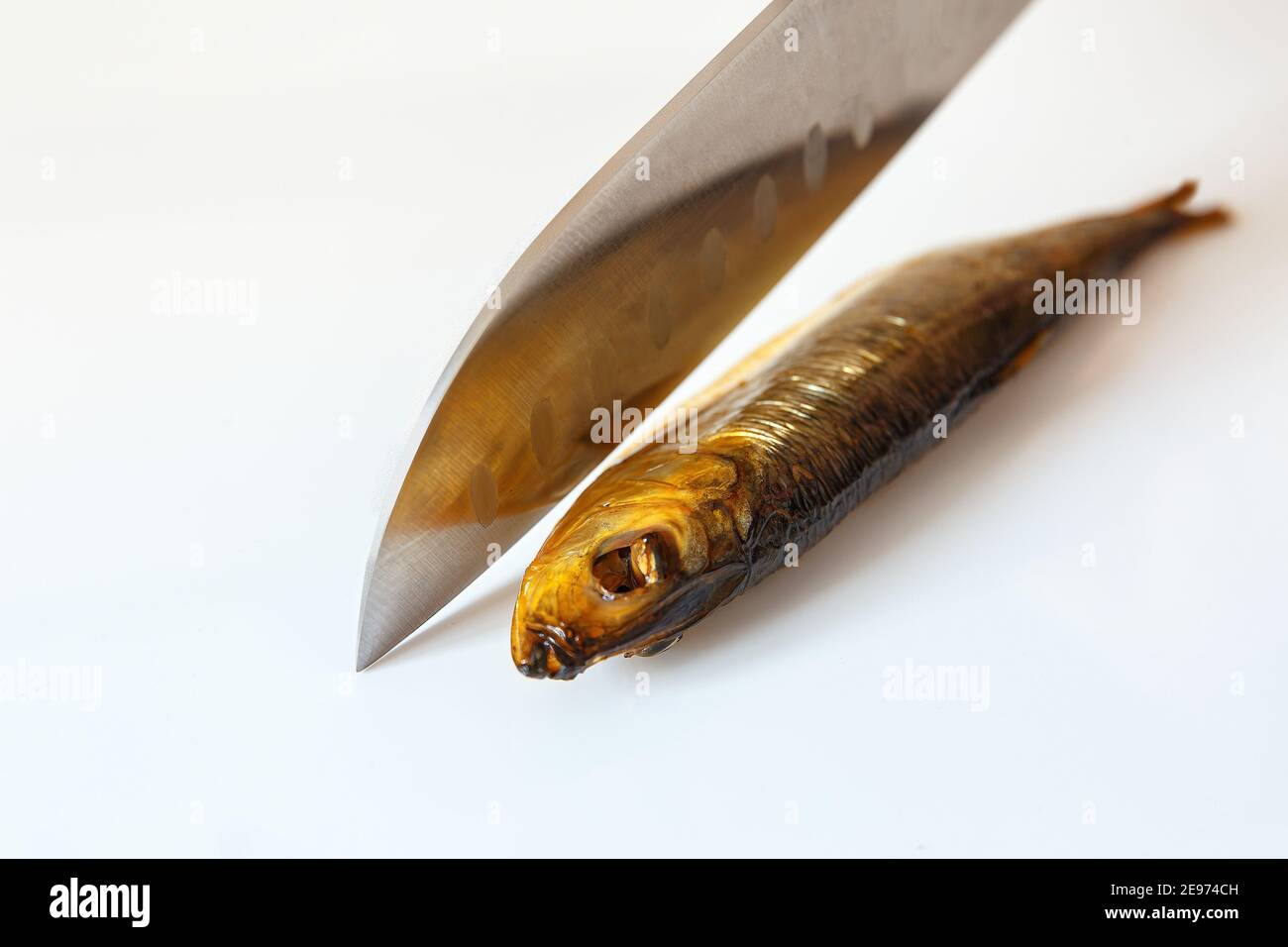 Small fish under a large knife on a white background Stock Photo - Alamy