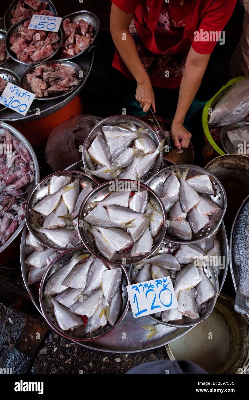 A fish market vendor cutting fish in half. headless fish for 120 Stock ...