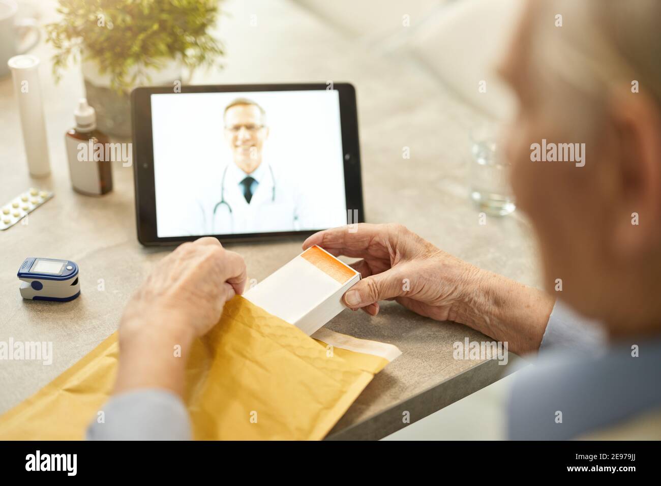 Senior man receiving medciation via mail delivery and video-calling his ...