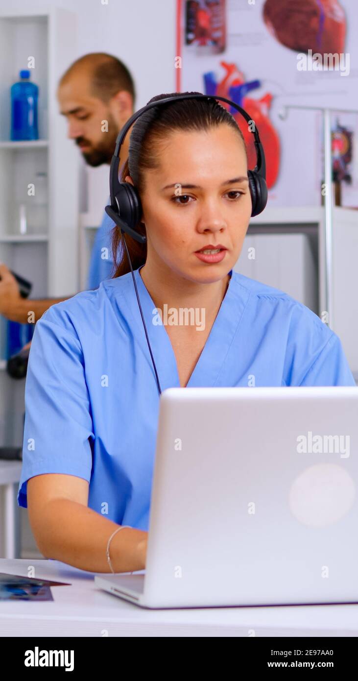 Medical assistant operator with headphone consulting patients during ...