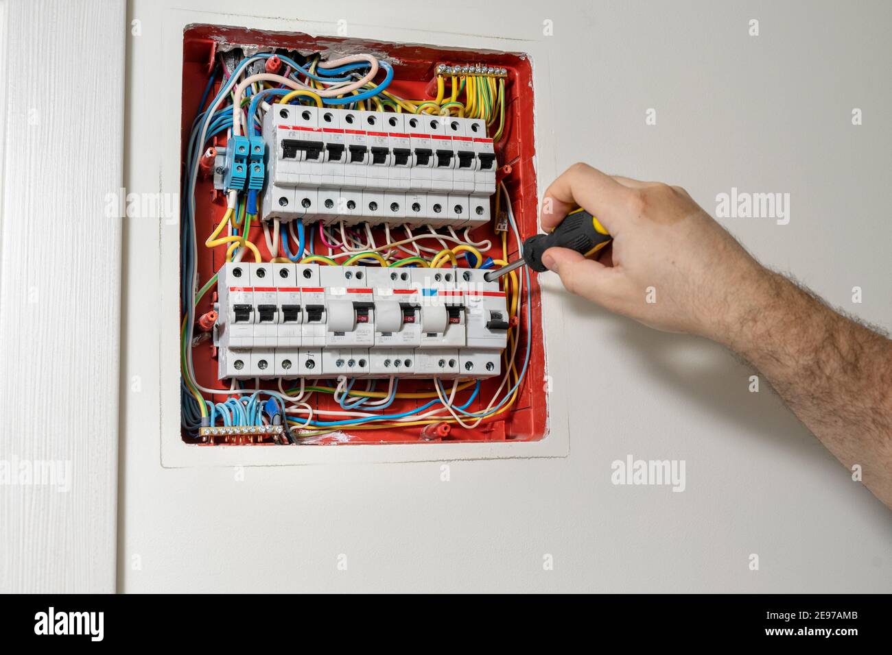 Electrician installing panel with electric meter in apartment of ...