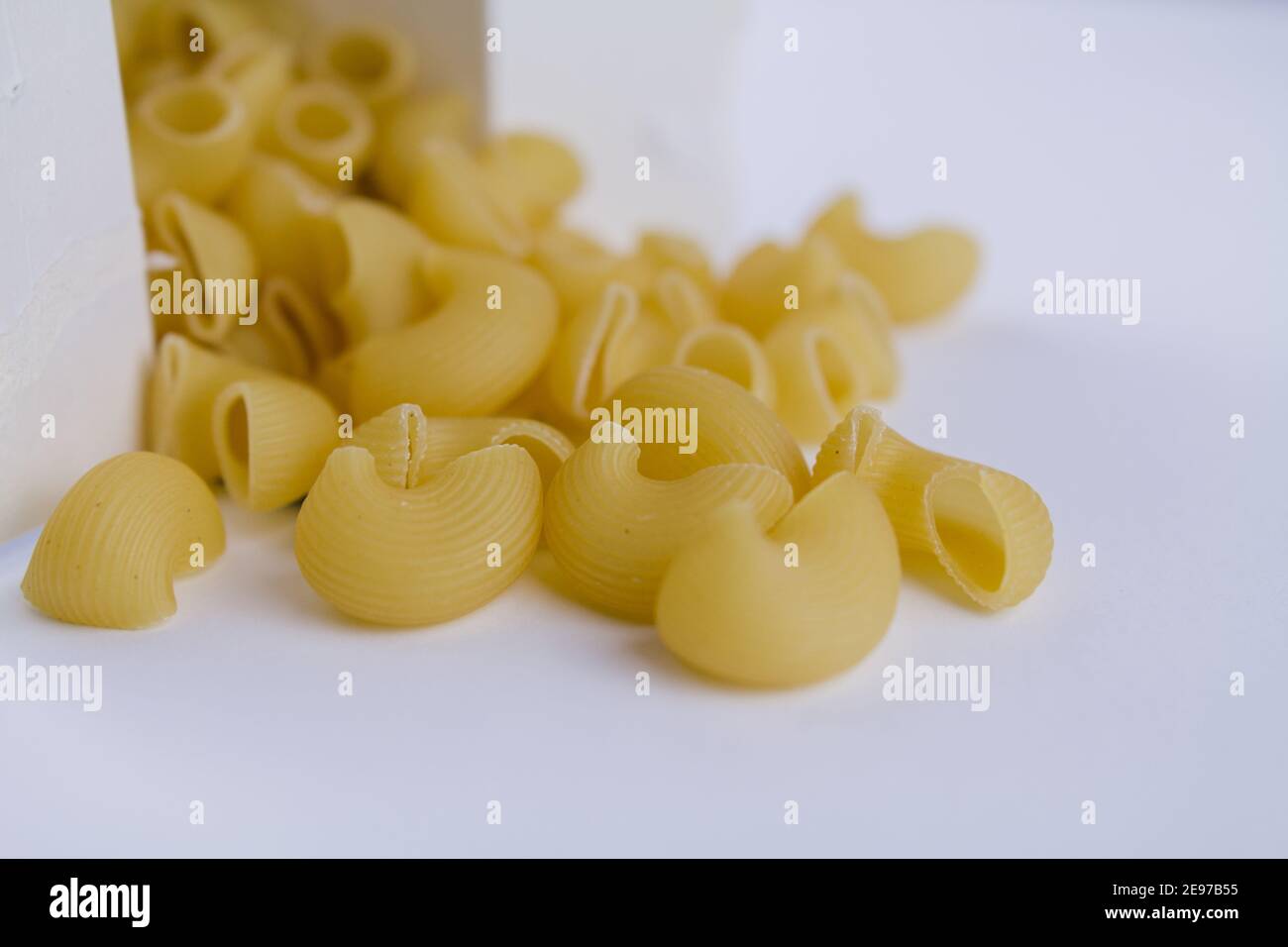 Italian durum wheat pasta poured from white box on the table Stock ...