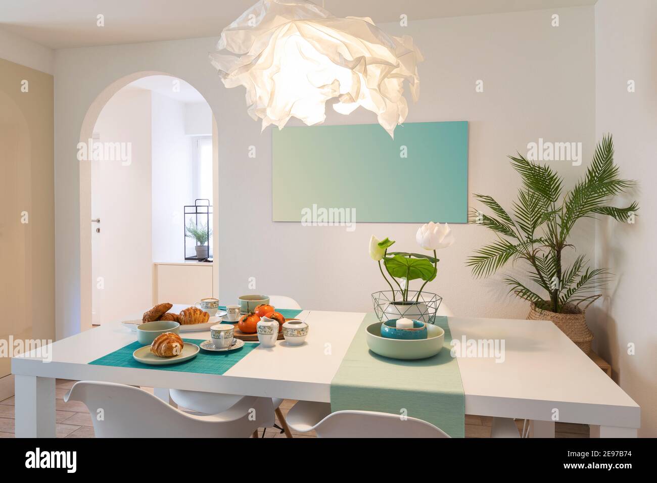 Elegant and romantic white table ready for breakfast with brioche, cups ...
